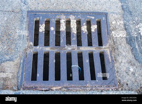 Cast Iron Manhole Of The Storm Sewer System On The Road In Front Of The