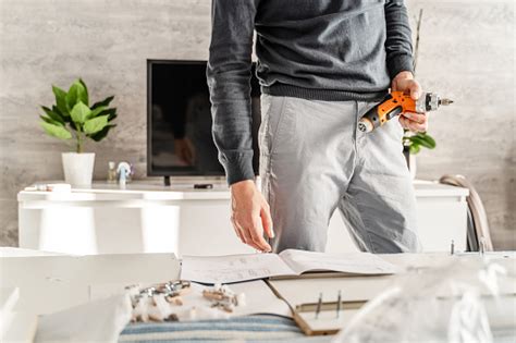 남자의 중간 넣어 함께 셀프 조립 가구 를 집에 전기 드라이버 찾고 지침을 찾고 절반 길이 전면 보기 Diy 개념 실제 사람들이 공간을 복사 35 39세에 대한 스톡 사진