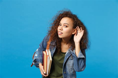 데님 옷에 젊은 슬픈 아프리카계 미국인 소녀 사춘기 학생 배낭은 파란색 배경 스튜디오 초상화에 고립 된 책을 보유 고등학교 대학 대학 개념에서 교육 복사 공간을 모의 합니다