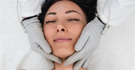 얼굴과 몸의 전기 자극 및 근육 토닝을위한 미세 감각 전기 바이오 Ems 미세 전류 치료 주름 방지 및 노화 방지 리프팅 전도성 장갑을 사용한 대체 요법 사진