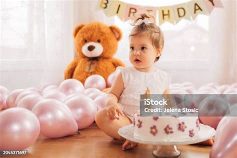 사랑스러운 여자 아기가 바닥에 앉아 1번째 생일 케이크를 어떻게 해야 할지 모르겠습니다 돌 생일에 대한 스톡 사진 및 기타 이미지 돌 생일 사진 촬영 이벤트 풍선