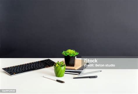 흰색 홈 오피스 테이블은 검은 색 배경에 복사 공간이 있습니다 컴퓨터 메모장과 즙이 많은 꽃 원격 작업을 위한 홈 오피스