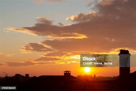 해질녘 아름 다운 하늘 석양의 광선에 밝은 주황색 구름 적운 구름 공중 배경입니다 굴뚝 집의 기와 지붕 해질녘 안개 속의 아름다운 구름 0명에 대한 스톡 사진 및 기타