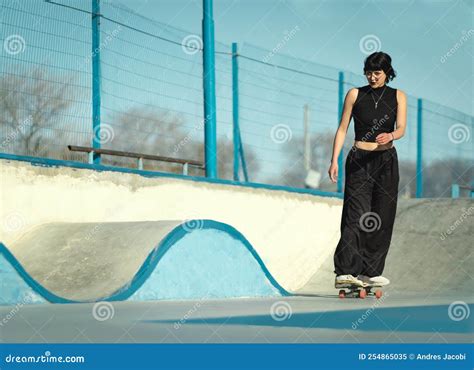 Cool Girl Riding Her Skateboard Concentrated In The Skate Park Stock