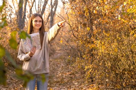 Real View Of A Stylish Woman Holding A Paper Map Pointing With Her