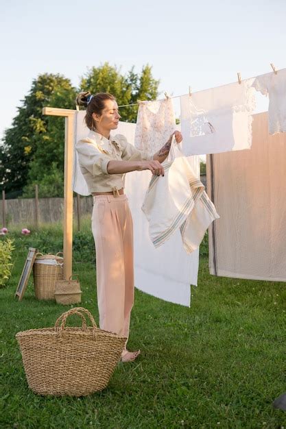 Premium Photo Laundry Day A Woman Hangs Linen And Towels On A Tree In
