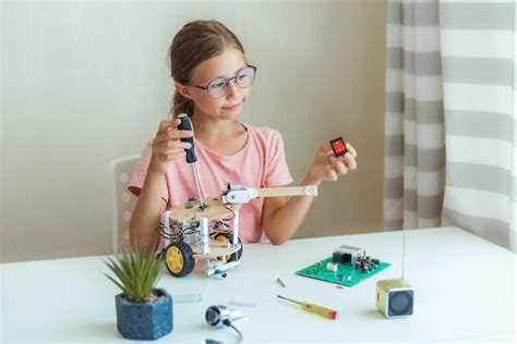 Premium Photo Smiling Cute Girl Constructs Metal Robot And Program It