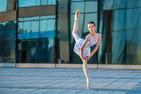 하얀 레오타드를 입은 젊은 발레리나 도시 경관을 배경으로 포인테 슈즈를 입고 춤을 추다 14 15 살에 대한 스톡 사진 및 기타 이미지 14 15 살 가냘픈 건강한