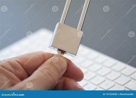 Fingers Turning A Key On Stainless Padlock In Front Of Computer Keyboard Pc Network Security