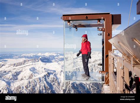 A Tourist Stands In The Step Into The Void Glass Box On The Aiguille