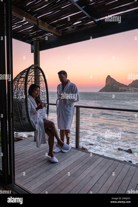 Couple Man And Women Drinking Coffee During On Balcony Sunrise At