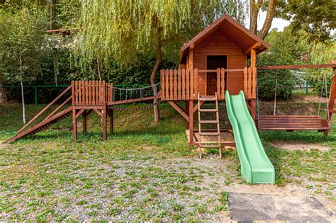 여름날 공공 공원의 녹색 마당에 자리 한 빈 현대 목조 어린이 놀이터 아이들을위한 재미있는 장난감 땅 야외 에서 어린이를위한 도시 운동 활동 이웃 어린 시절 개념 0명에