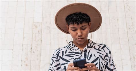 젊은 아프리카 여자 스마트폰을 들고 거리에 서서 보고 있다 사진 Unsplash의 여성 동성애자 이미지