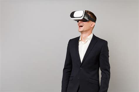 고전 검은 양복 스튜디오에서 회색 벽 배경에 고립 된 헤드셋을 찾고 셔츠에 젊은 비즈니스 남자를 웃 고의 초상화 업적 경력 자산 사업 개념 복사 공간을 모의 합니다 검은색에