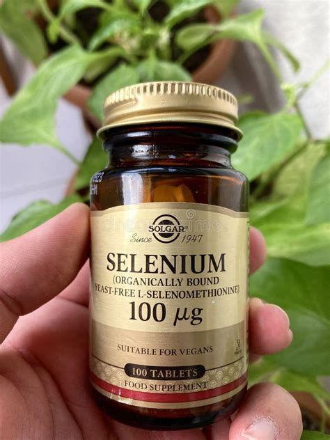 Man Holding Solgar Selenium Bottle With Green Background Editorial Photography Image Of