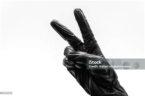 검은 장갑을 끼고 돌아온 여성의 손은 흰색 배경에 고립 된 제스처 표지판 및 기호를 보여줍니다 두 손가락을 상단에 접고 V의 형태로 접혀 승리 또는 평화를 의미 가죽에 대한