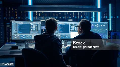 데스크톱 컴퓨터 디스플레이에 표시된 블록 체인 데이터 네트워크 아키텍처 설계 및 개발에 대해 논의하는 두 명의 전문 It 프로그래머 서버 랙이 있는 작업 데이터 센터 기술