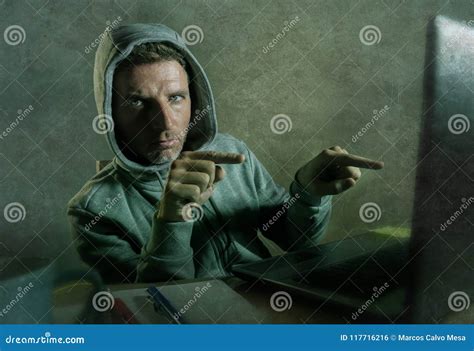 dangerous looking hacker man in hoodie hacking internet computer system