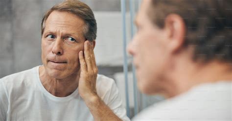 거울에 비친 자신을 응시하는 집중된 잘생긴 백인 중년 남성의 초상화를 클로즈업합니다 사진 Unsplash의 스킨 케어 이미지