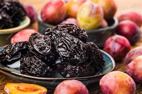 Premium Photo Fresh Prune And Dried Prune On Wooden Board Wall