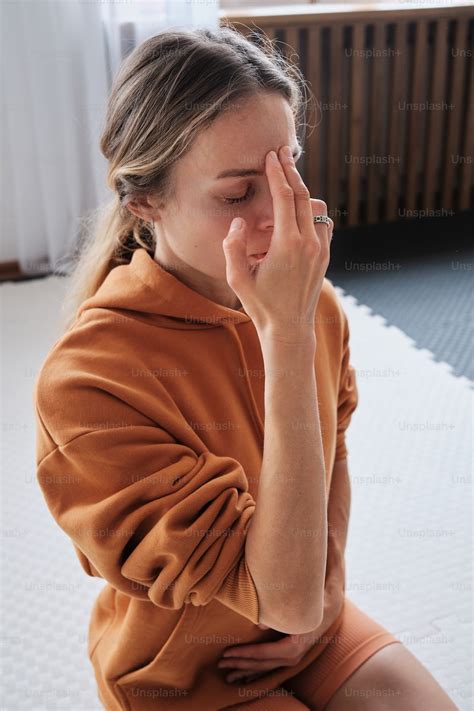 바닥에 앉아 있는 여자가 얼굴에 손을 대고 있다 사진 Unsplash의 여자 이미지