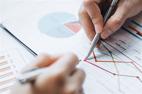 두 명의 사업가가 공동의 비즈니스 문제를 개발하고 해결하기 위해 함께 노력하면서 회의 자료를 지적했습니다 성장과 품질을 위한 비즈니스 관리 개념 개념에 대한 스톡 사진 및