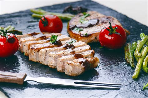 구운된 돼지고기 볶음 야채 토마토 콩 블랙 슬레이트에 소스와 스테이크 거품과 신선한 고기입니다 어두운 배경입니다 구이 및 바베 큐 개념 가금류에 대한 스톡 사진 및 기타