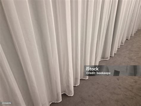 커튼은 천장에서 바닥까지 매달려 있습니다 부드러운 새틴 합성 커튼이 공간을 나누고 부드러운 섬유 배경을 형성합니다 직물 가장자리 하단의 무게 0명에 대한 스톡 사진 및 기타