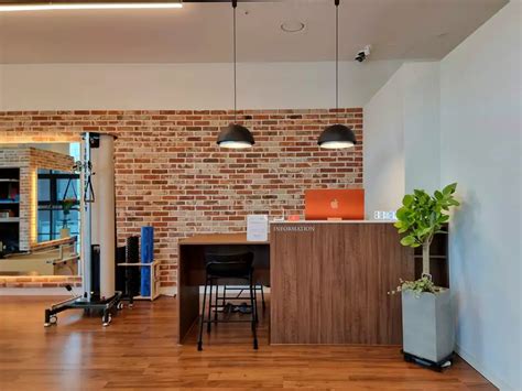 벽돌 포인트 벽과 우드톤 데스크가 있는 필라테스 인포 사진