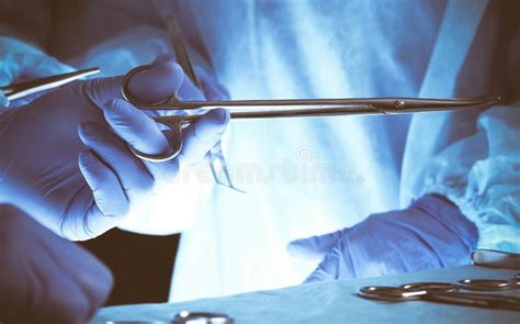 Surgeons Hands Holding Surgical Scissors And Passing Surgical Equipment Close Up Health Care