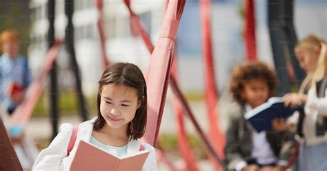 학교 운동장에서 반 친구들과 함께 야외에서 책을 읽고 있는 아시아 여학생 사진 Unsplash의 여름 이미지