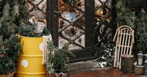 크리스마스 거리 장식입니다 빨간 열매 문에 화환 도시 거리의 휴일 시장에서 상점 앞에 나무 썰매가 있는 세련된 크리스마스