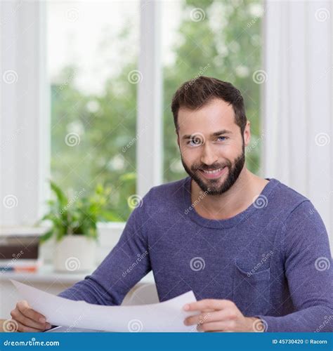 Красивый человек в рубашке голубого серого цвета военно морского флота держа бумагу Стоковое