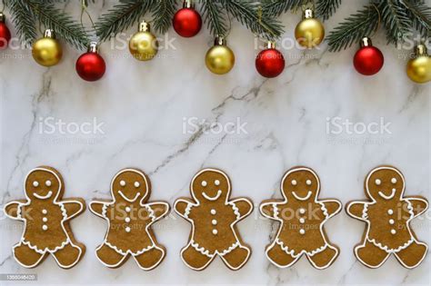 수제 진저 브레드 남자 비스킷의 이미지 흰색 대리석 효과 배경에 왕실 아이싱 가문비 나무 바늘과 빨간색과 금 장식의 프레임 높은 전망 크리스마스 장식품에 대한 스톡 사진 및