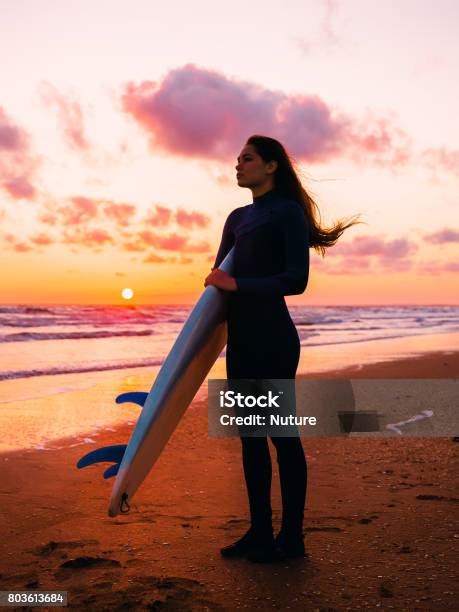 긴 머리와 따뜻한 일몰이 나 일출에서 비치에 서핑 보드와 잠수복에 슬림 여자의 실루엣 서퍼와 바다 가냘픈에 대한 스톡 사진 및 기타 이미지 Istock