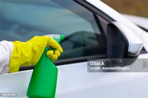 노란 고무 장갑을 낀 손이 따뜻한 가을 날에 스프레이 병에서 자동차 창문에 물을 뿌린다 젖은 청소 선택적 초점 Workers Party에 대한 스톡 사진 및 기타 이미지