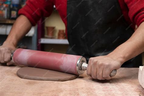 Premium Photo Potter Using A Rolling Pin To Flatten A Lump Of Clay