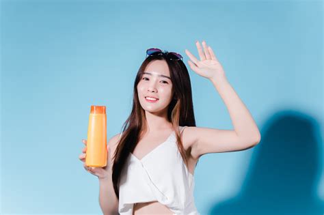 매력적인 아시아 뷰티 우먼은 파란색 배경에 자외선 차단 Uv 또는 자외선 차단제로 선크림과 컬러 스케일을 들고 있습니다 18