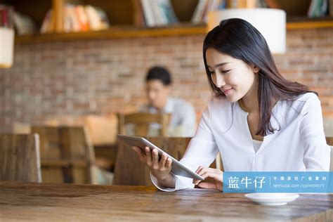 年轻女子在咖啡馆使用平板电脑 蓝牛仔影像 中国原创广告影像素材