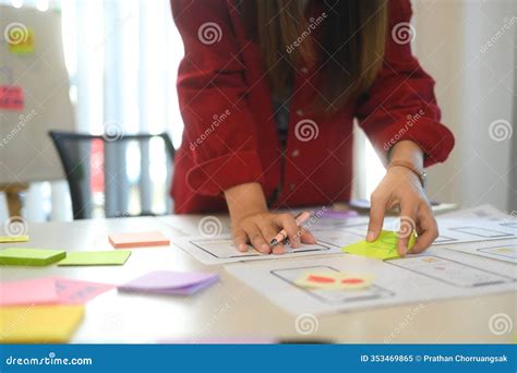 Team Of Creatives Collaborating On A Ux Ui Project At Workspace Filled With Flowcharts And