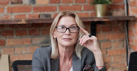 안경을 쓴 진지한 성숙한 여성 사업가의 초상화는 로프트 사무실의 책상에 앉아 있다 사진 Unsplash의 컴퓨터 이미지