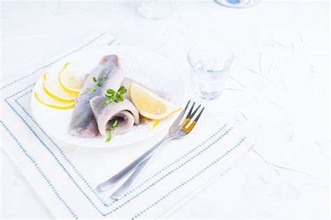 레몬과 양파와 흰색 접시에 절인된 청 어 필렛 테이블 및 네덜란드의 전통적인 봄 진미를 제공합니다 네덜란드에 있는 일반적인 요리 생선 텍스트에 대 한 여유 공간입니다 건강한