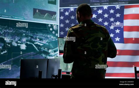 Professionals In Us Military Uniforms Operate Computers And Big Screen Working On Surveillance
