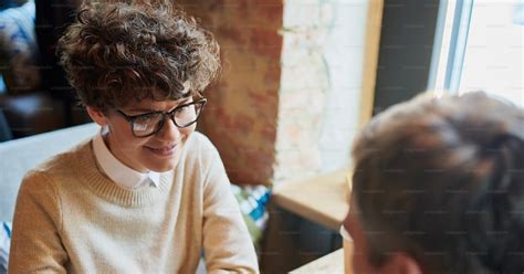 작업 회의에서 터치패드로 계획을 논의하는 동안 동료의 말을 듣고 있는 꽤 젊은 엔지니어 사진 Unsplash의 동료 이미지