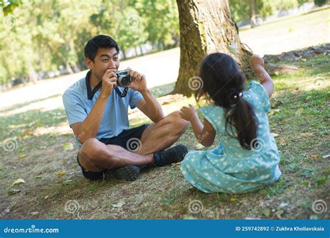 Asian Father Getting Ready To Take Photo Of His Kid On Field Stock Photo Image Of Ethnic Park