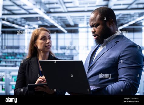 Employee In Server Hub Showing Manager Recovery Plan On Laptop