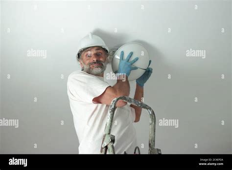 Man Installing A Lamp On The Ceiling Stock Photo Alamy