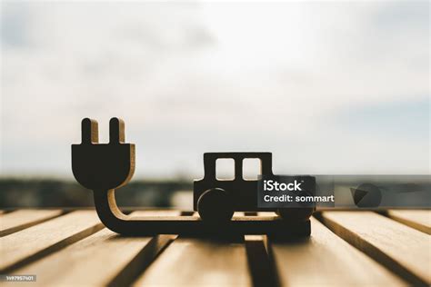 전선과 리튬 배터리가 있는 목조 자동차 연결된 충전 케이블이 있는 기술 배터리 고출력 전기 에너지 깨끗한 전기로 전기 자동차 및