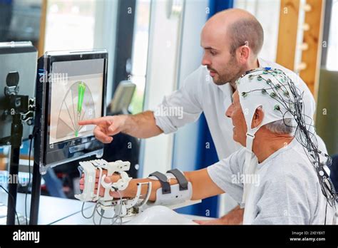 investigator and patient with assistive robot for upper limb