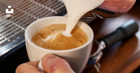 갈색 액체가 든 흰색 세라믹 머그잔을 들고 있는 사람 사진 Unsplash의 무료 커피 이미지